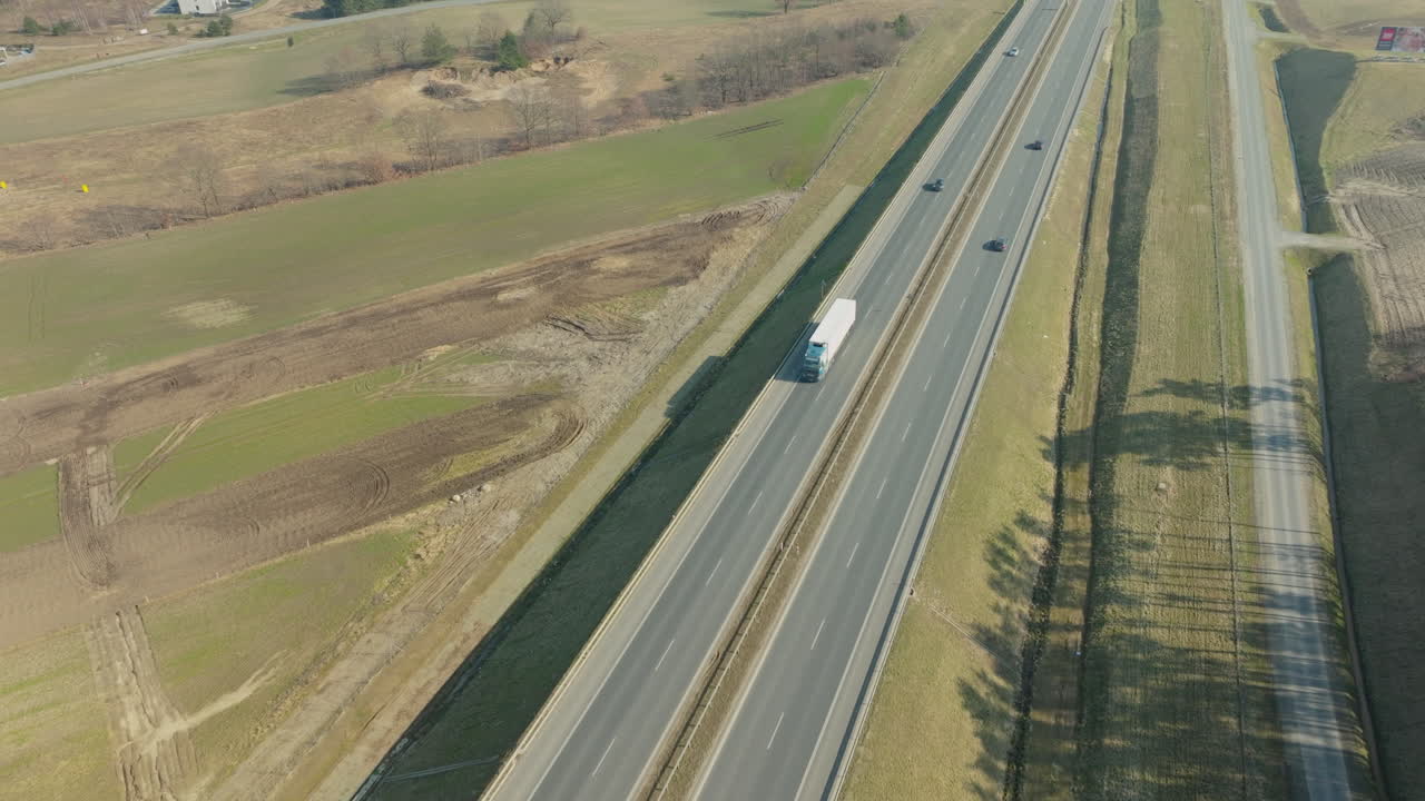 Cars and truck driving through the highway along the countryside road ...