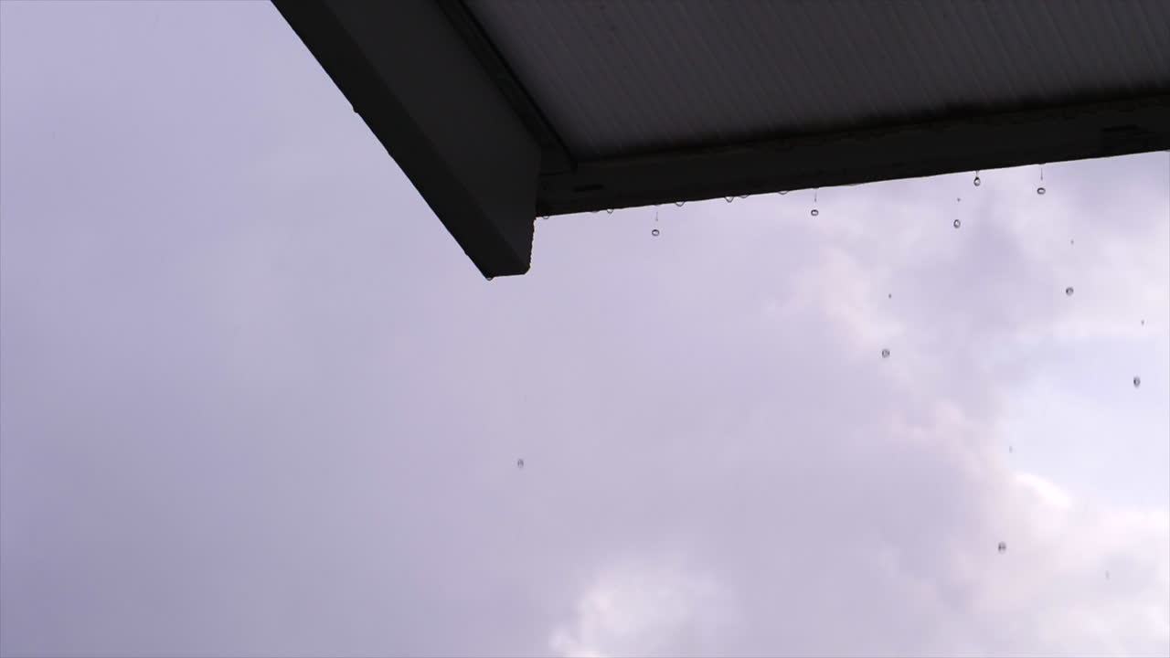 Rain drops slowly falling from rain pipe | วิดีโอสต็อกแบบ พรีเมี่ยม