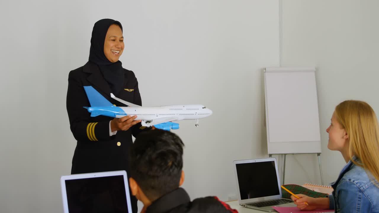 Premium stock video - Female pilot teaching about model plane to kids 4k