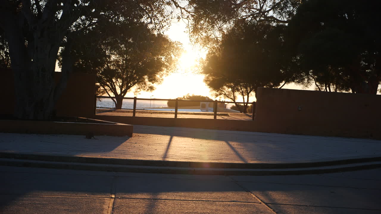 Premium stock video - Walking through sunset sun flare