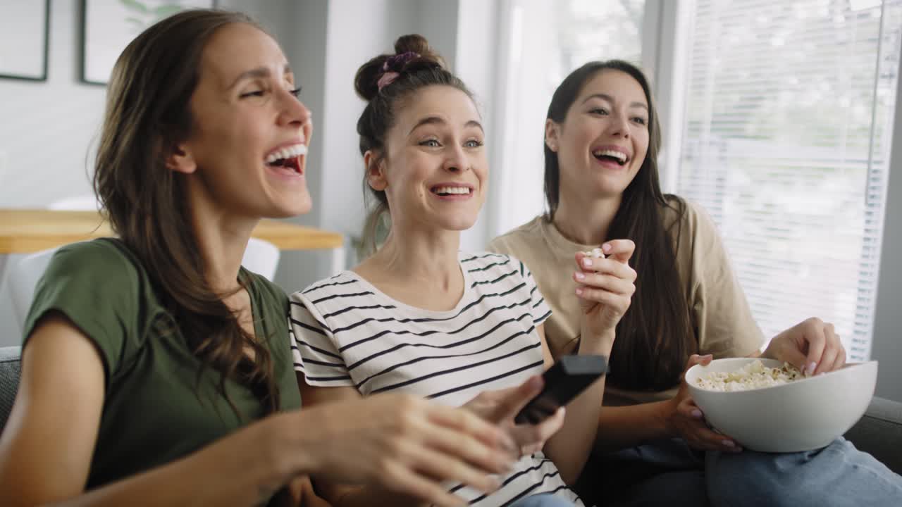 Zoom Out Video Of Friends Watching TV And Eating Popcorn Free Stock ...