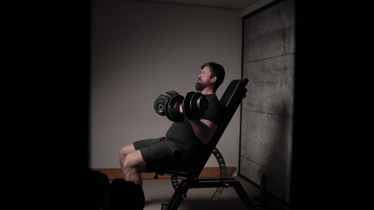 Premium stock video - Seated dumbbell bicep curls, cinematic lighting ...