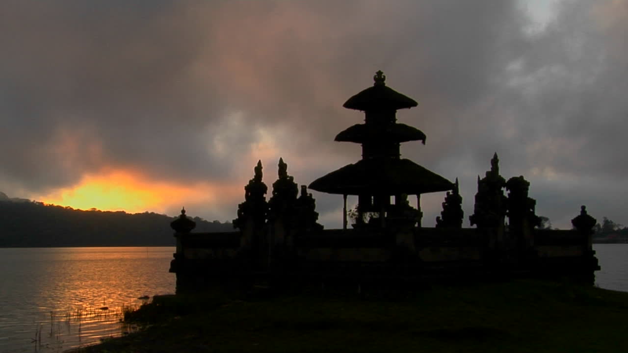 Premium stock video - A balinese temple overlooks reflections in a lake