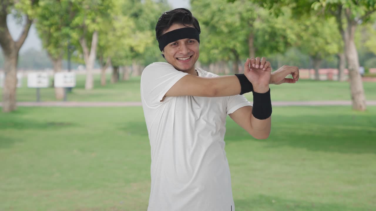 Premium stock video - Happy indian man doing arm exercise