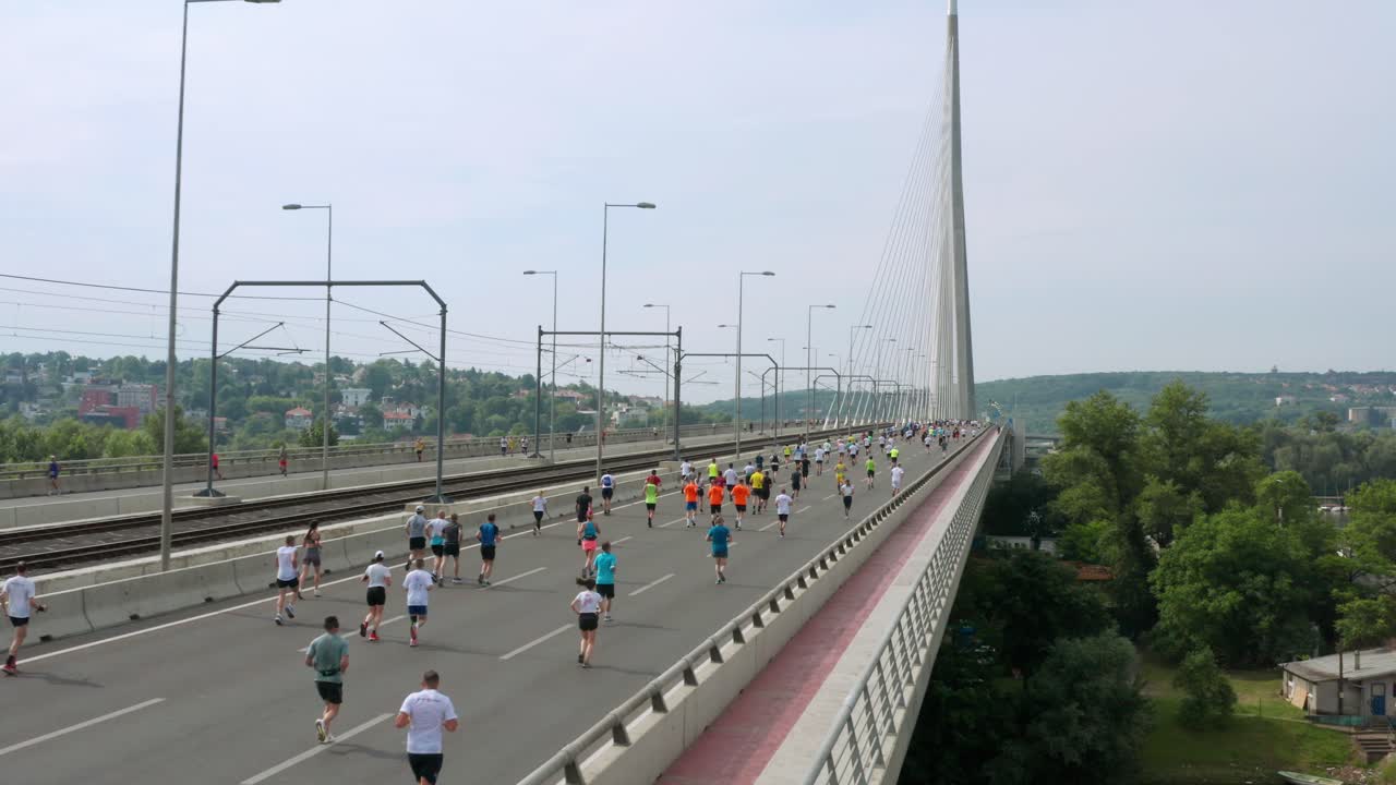 Premium stock video - Group of runners running on a bridge during the ...