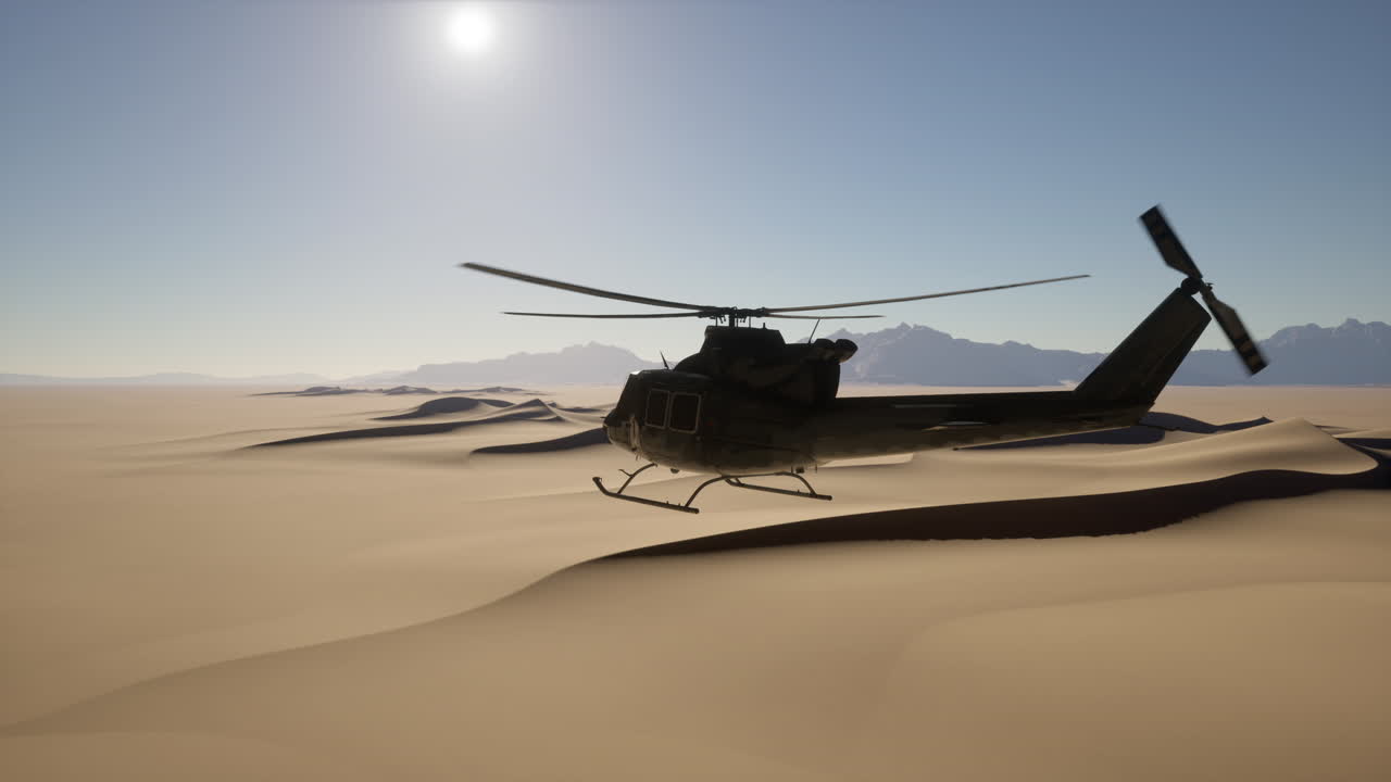 Premium stock video - Military helicopter flying low over desert sand dunes