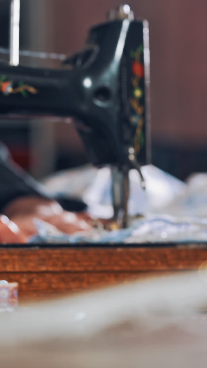 Female tailor works on a sewing machine at her workplace. Successful ...