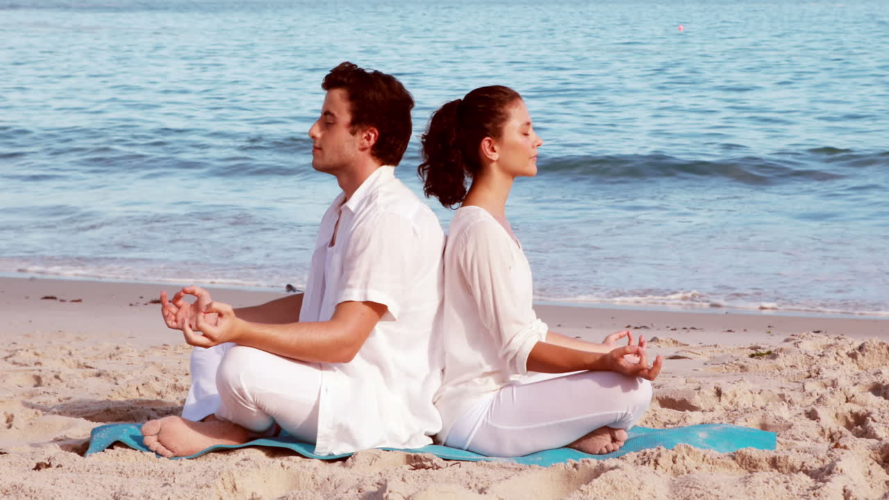 Peaceful Couple Meditating In Lotus Pose At The Beach Free Stock Video ...