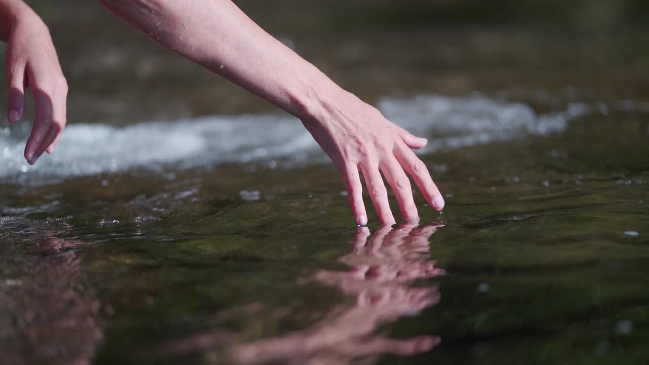 Hand moving over water | Premium Stock Video Footage
