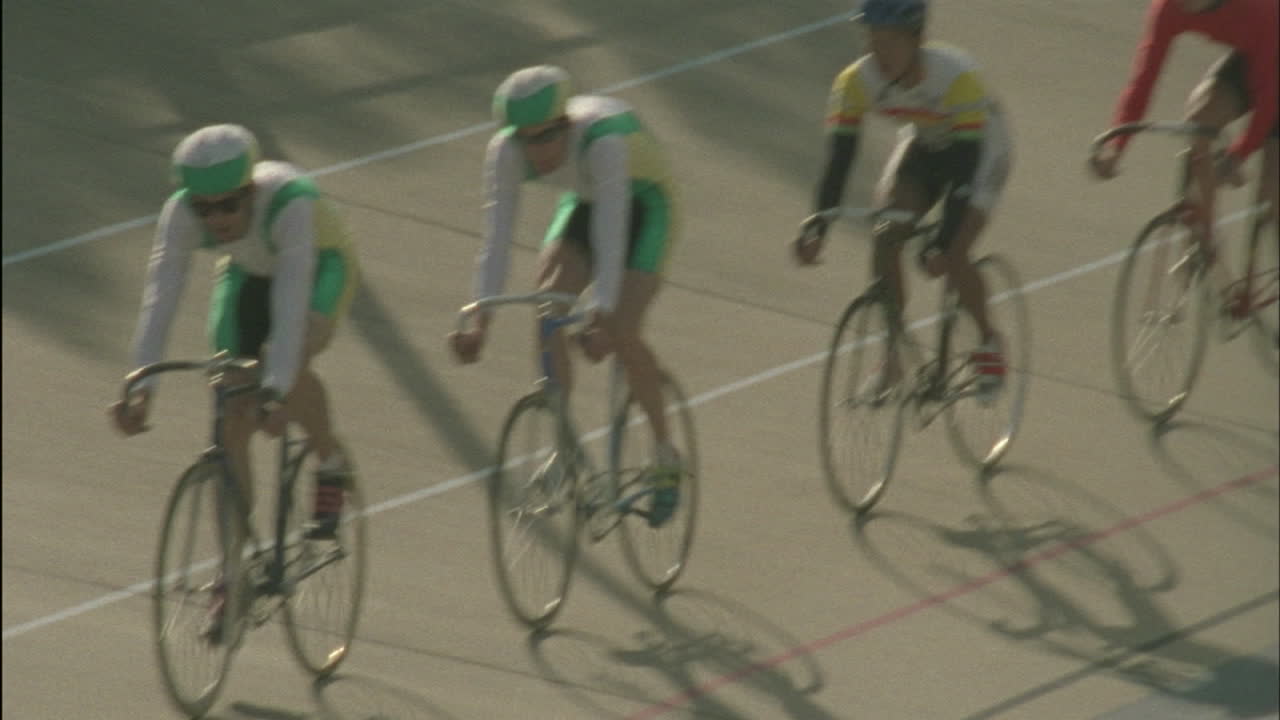Premium stock video - Cyclist ride in line around a track