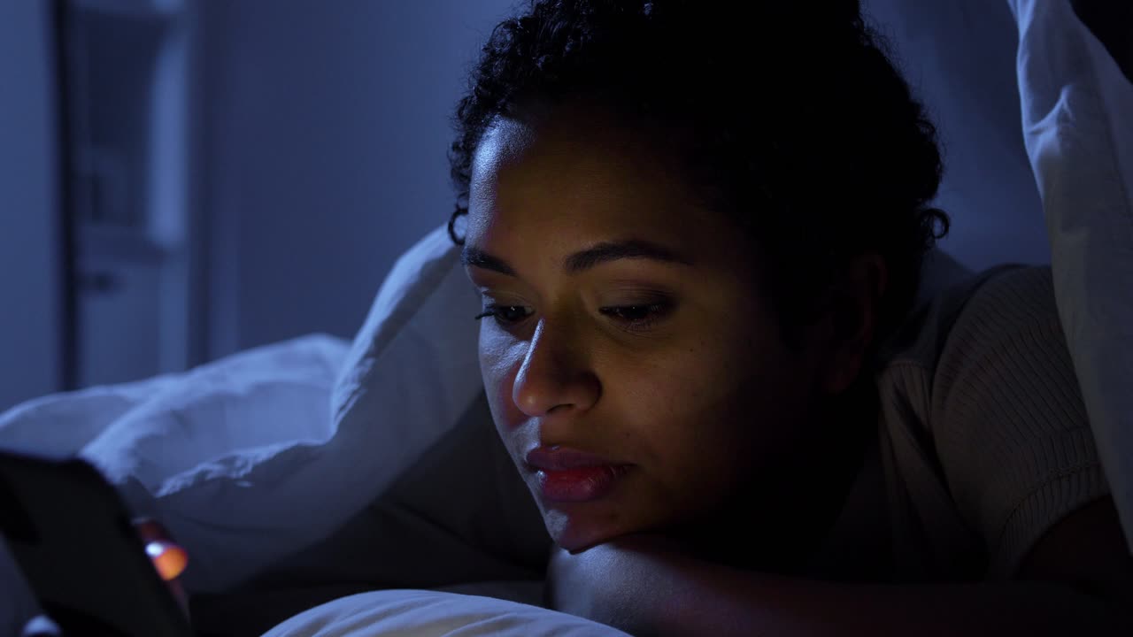 Premium stock video - Woman with smartphone in bed at home at night ...