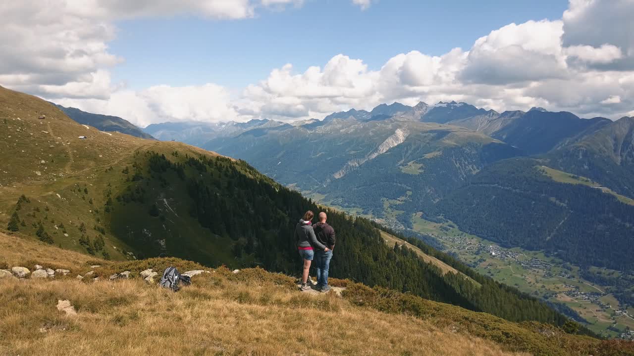 Drone shot rotating behind a couple man and woman standing on a ...
