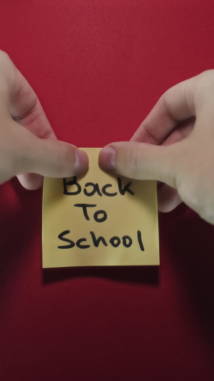 Posting Back To School sticky note on red wall, reflecting education ...