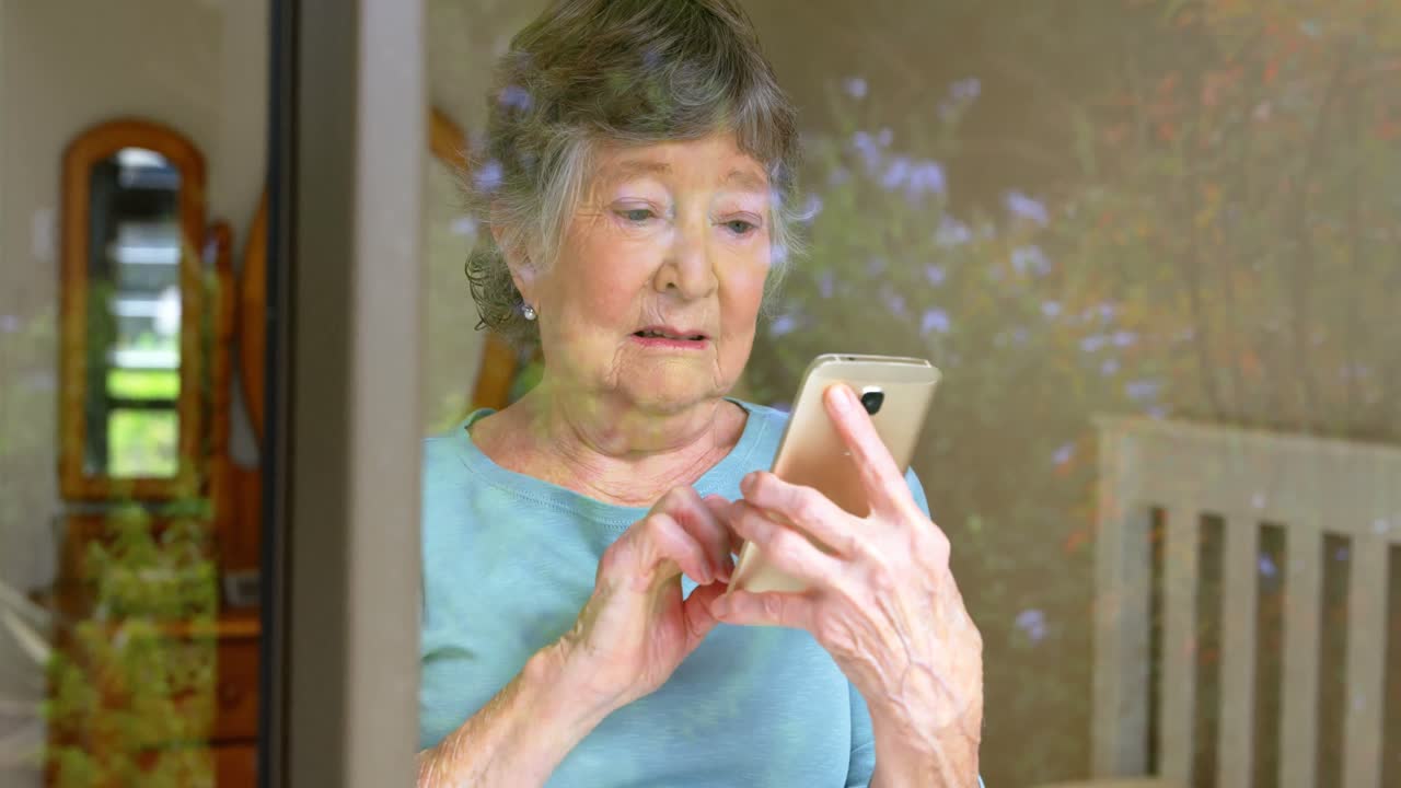 Premium stock video - Senior woman using mobile phone 4k