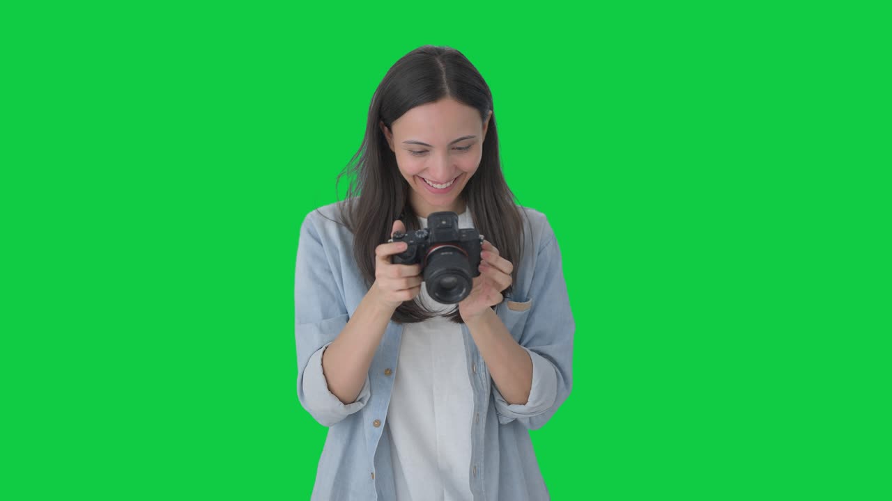 Premium stock video - Happy indian girl clicking photos using a camera ...