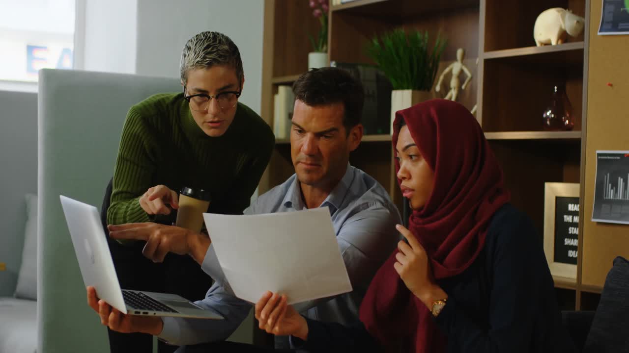 Premium stock video - Executives discussing over laptop and document 4k