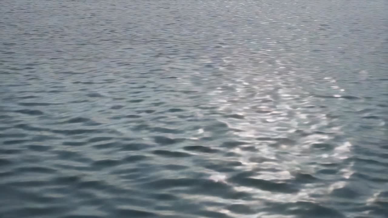 Sunlight glint appearing, rippling water surface shifting as small ...