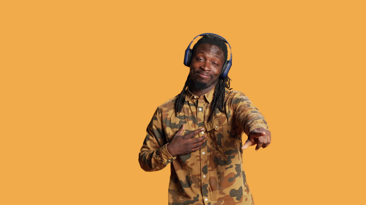 Premium stock video - African american guy enjoying music on headphones