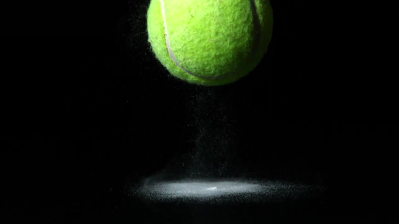 Premium stock video - Tennis ball falling on black background