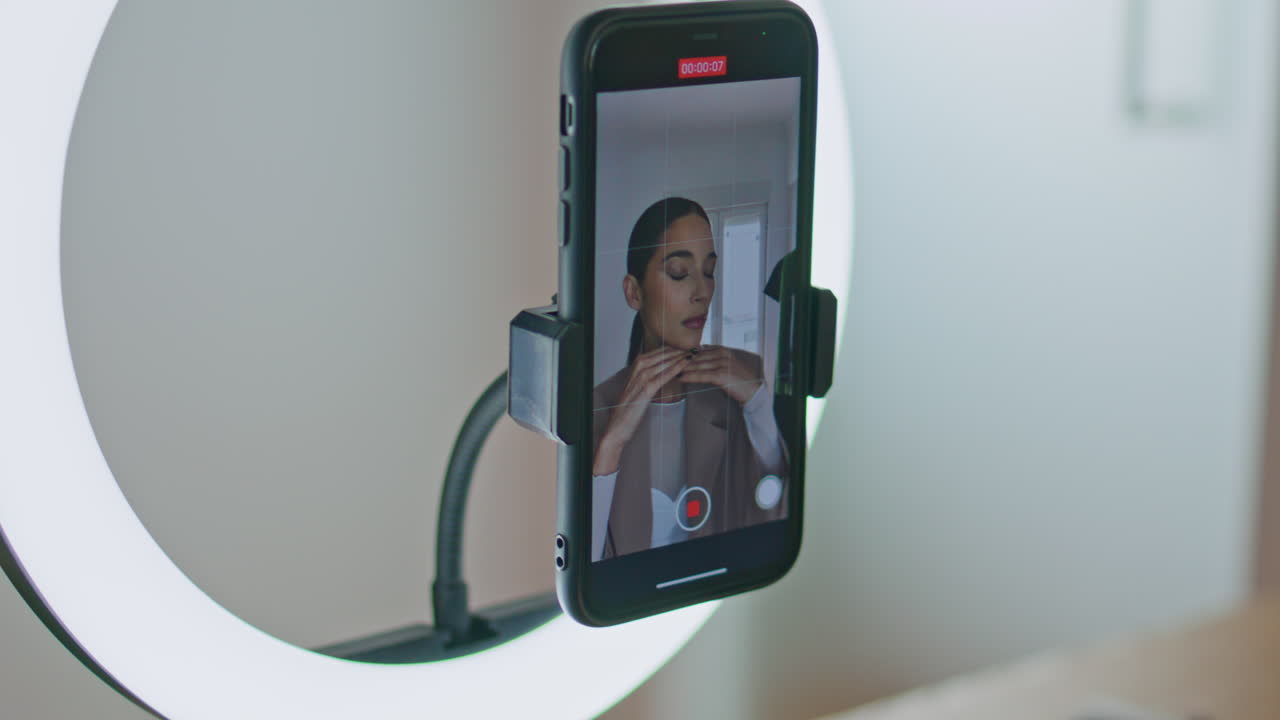 Woman influencer reviewing online mobile phone view at house. Blogger ...