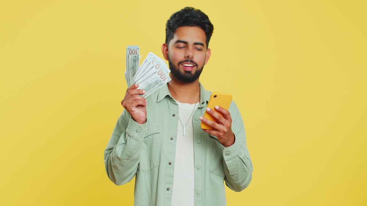 Happy indian man use smartphone rejoicing game win receiving money ...
