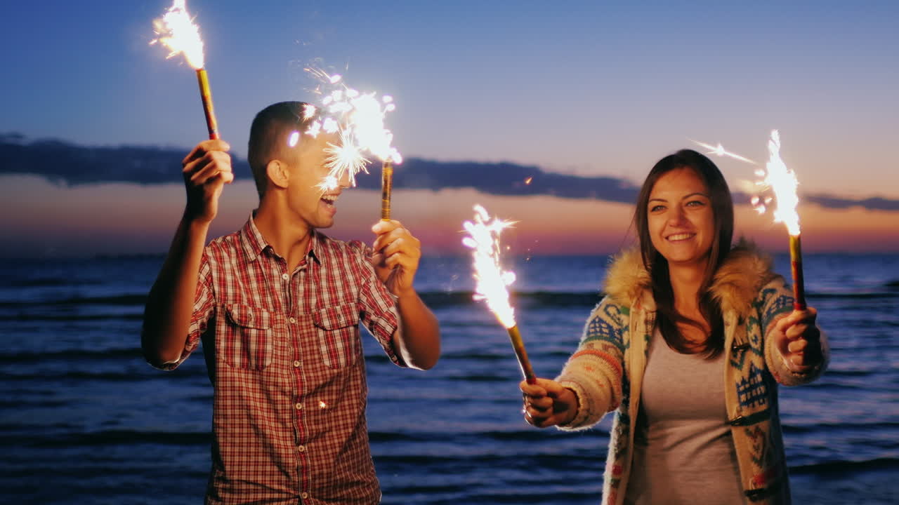 Young Couple Having Fun With Fireworks In The Hands Fireworks Lit The ...
