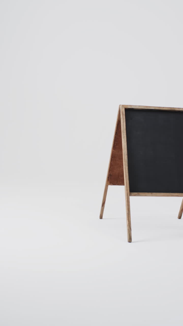 vertical video of blackboard sign on wooden stand with copy space on ...