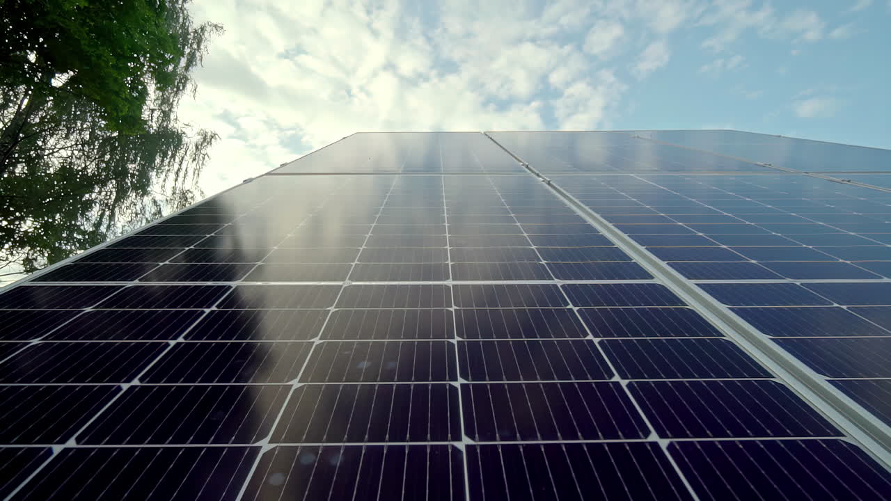 Side ways movement along solar panels with a partly cloudy blue sky in ...