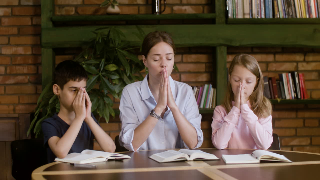Free stock video - Two pupils praying in class with their teacher