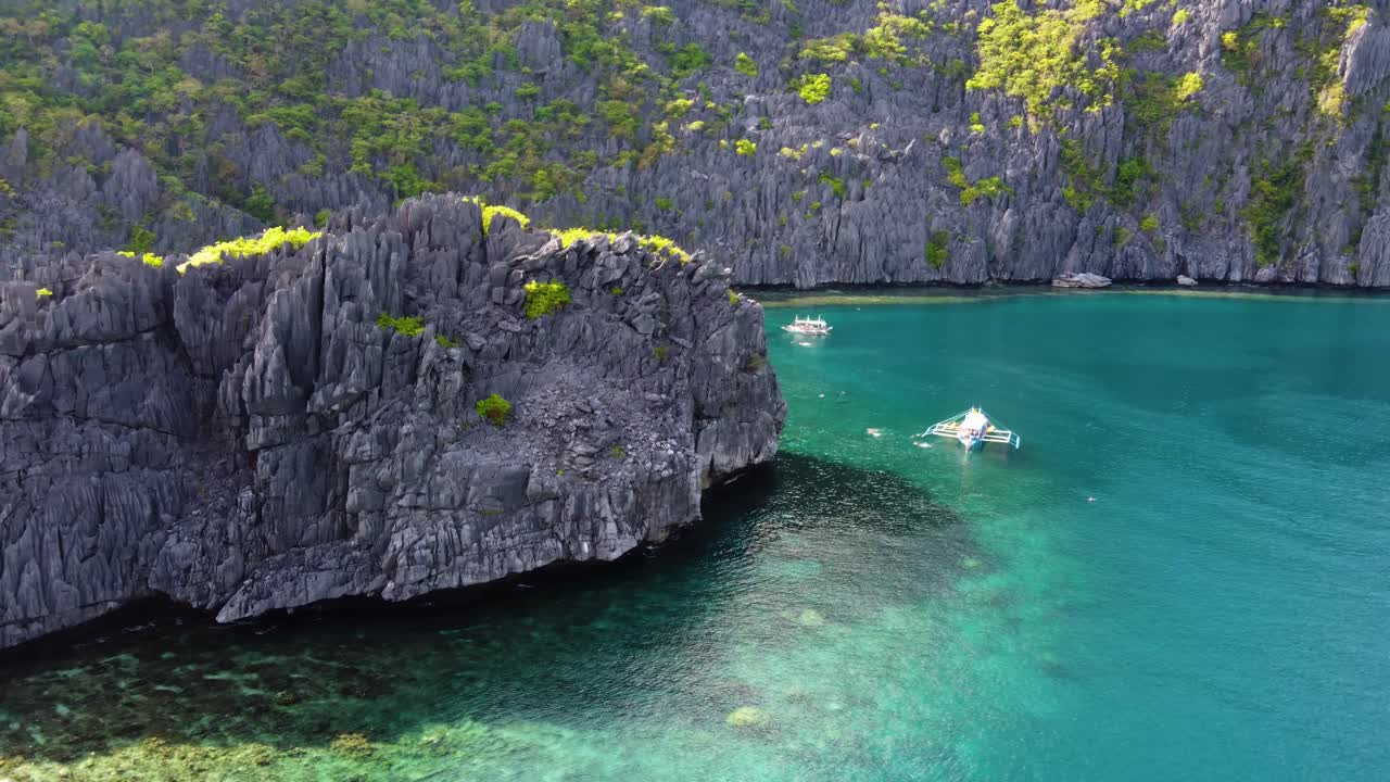 Tour boats next to star beach bay of tapiutan island in el nido tour c ...