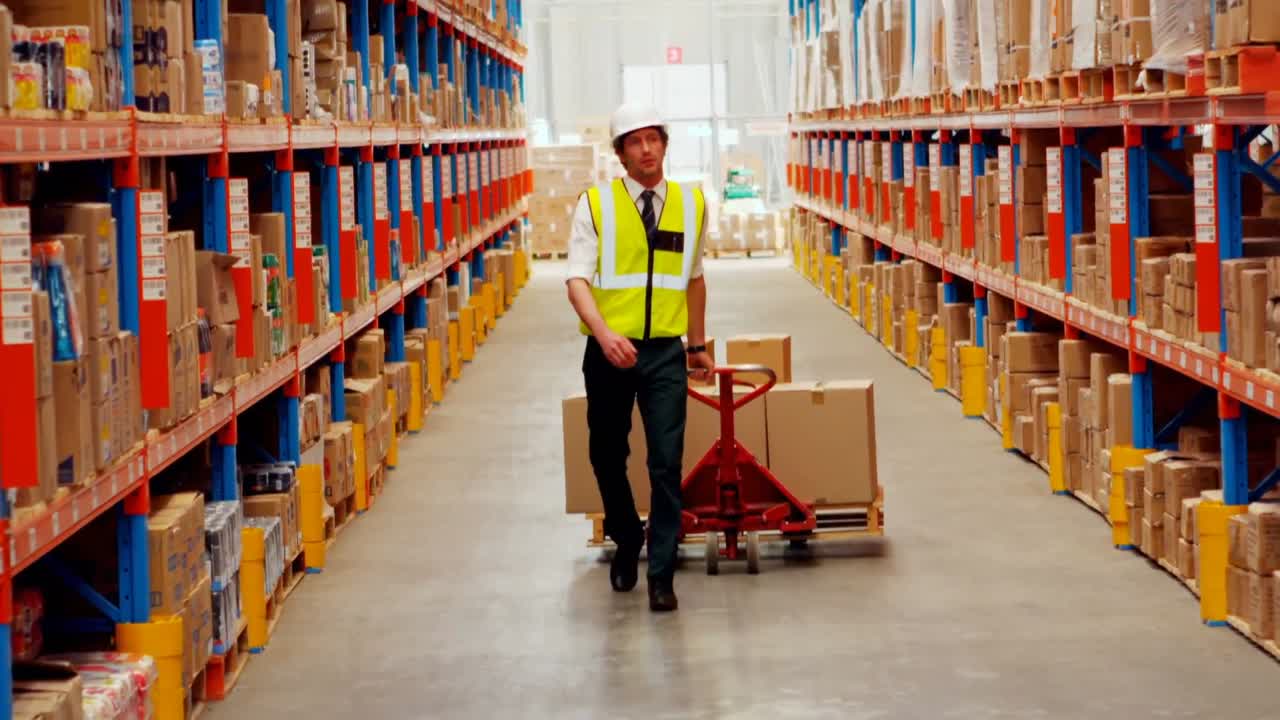 Premium stock video - Male worker walking with a pallet truck