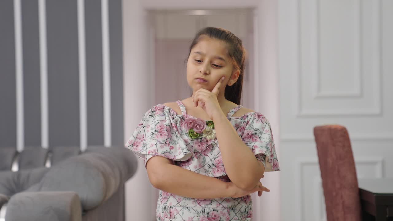 Premium stock video - Confused indian kid girl thinking about something