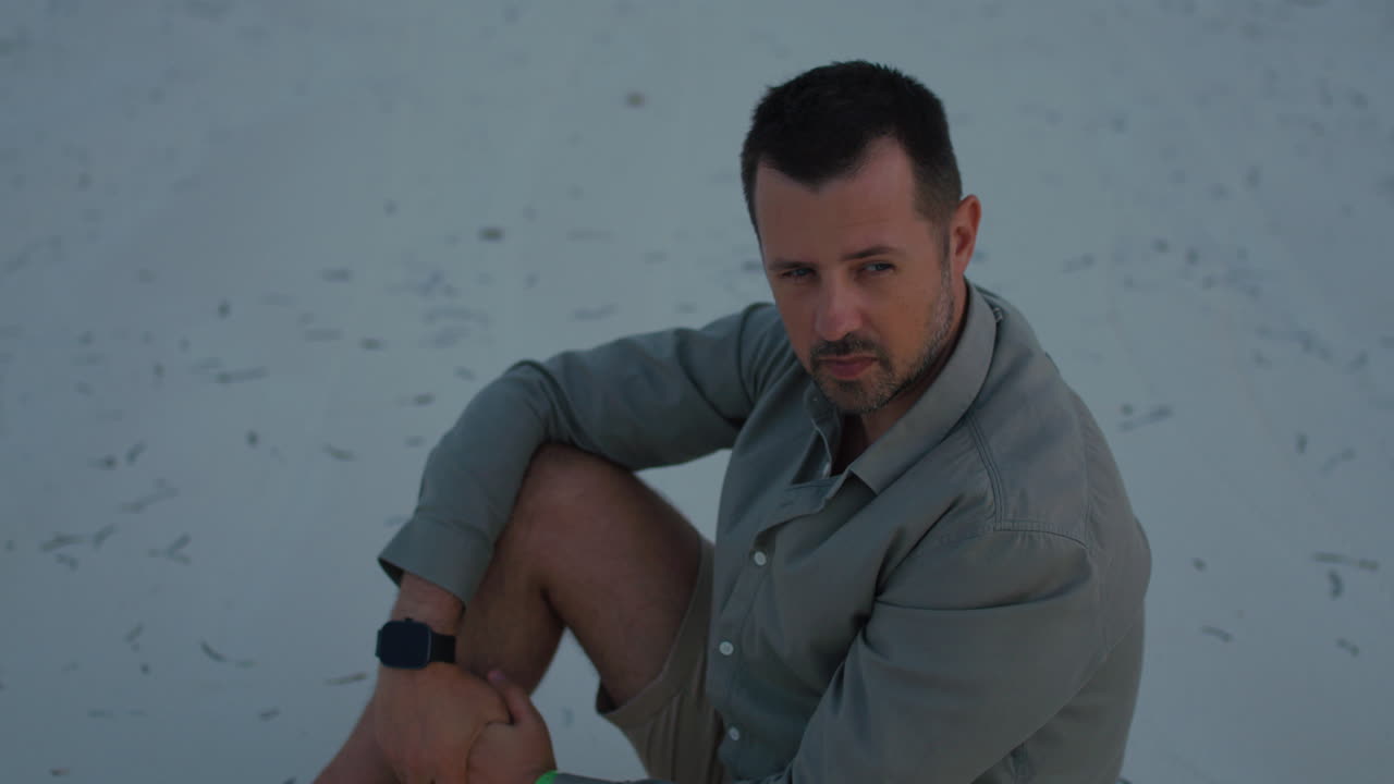 Premium stock video - Lonely and sad man sits on white sand beach in ...