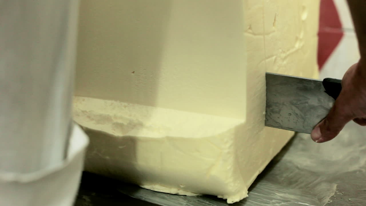 Premium stock video - Butter block cutting. big stick of butter cutting ...