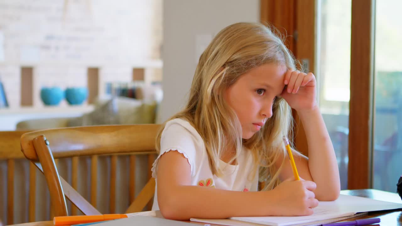 Premium stock video - Girl doing her homework at home 4k