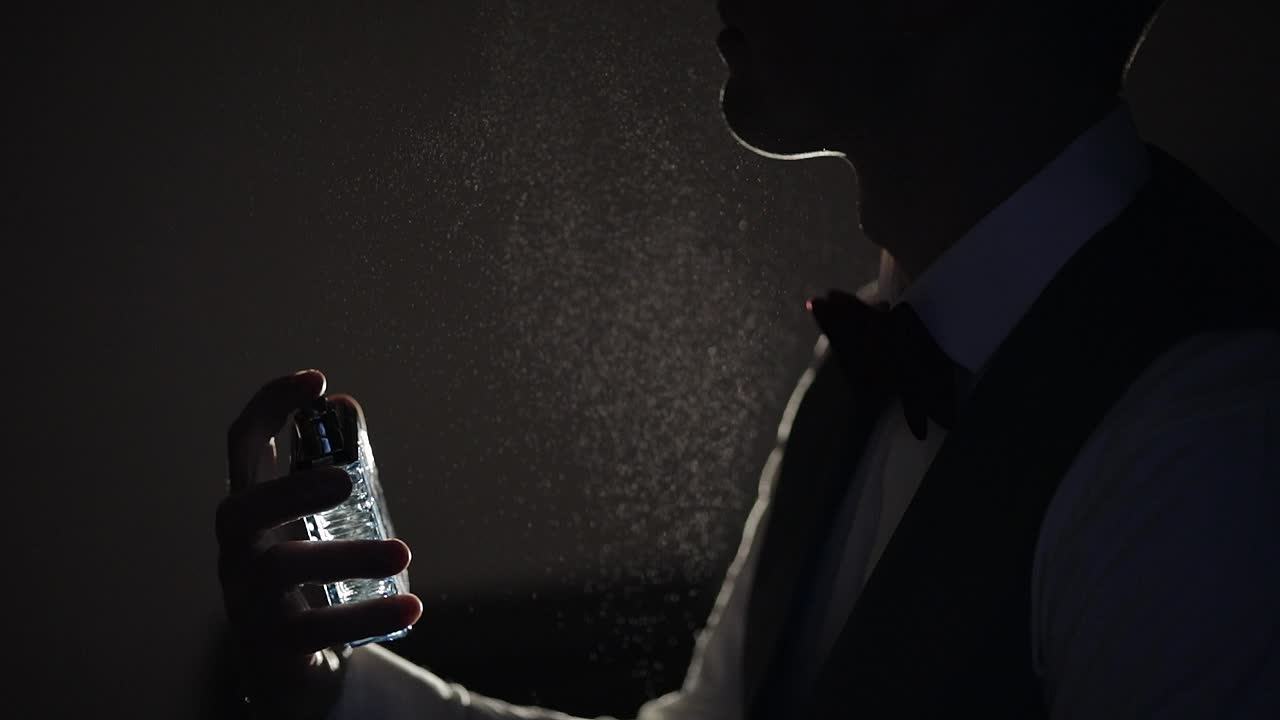 Man spraying cologne before an event Premium Stock Video Footage