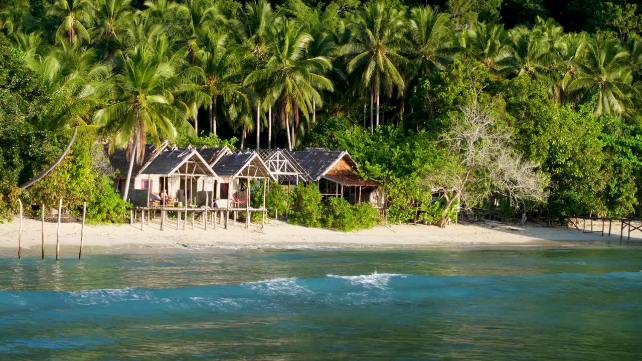 Simple Wooden Huts With Rainforest Trees On White Sandy Beach ...