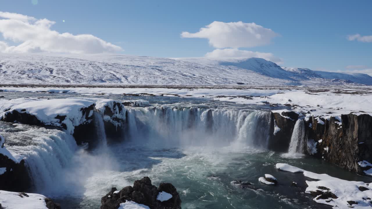 Reveal of crystal clear water pool of Godafoss waterfall during blue ...