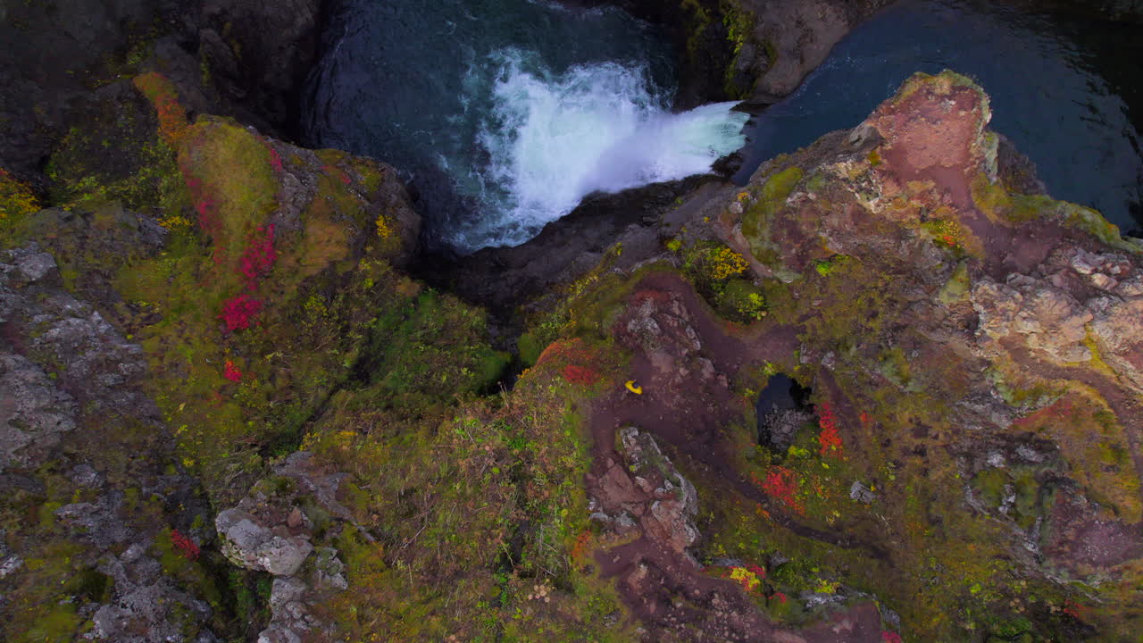 Man walking on top of waterfall canyon in autumnal Iceland | Premium ...