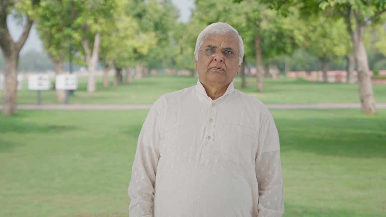 Premium stock video - Sad indian old man watching something tragic in park