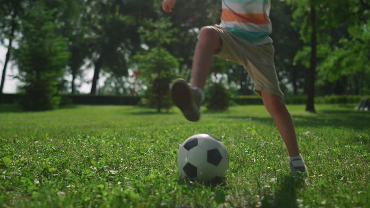 Happy boy play football on sunlight in park. kid make soccer exercise on nature. Premium Stock ...