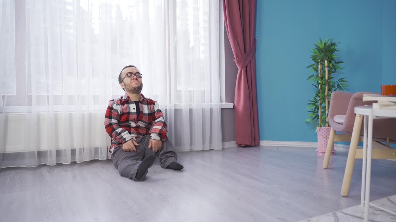 Premium stock video - Depressed dwarf man sitting on the floor at home ...