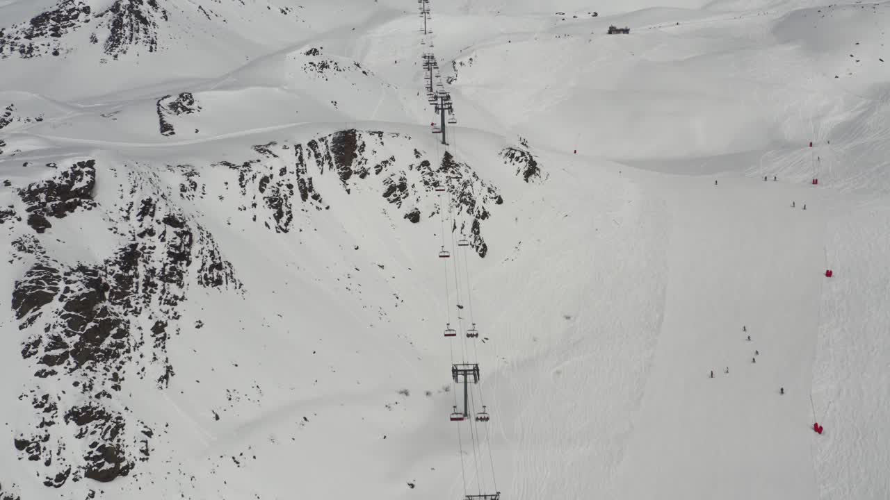 Tilt Down Drone Shot Of Very Long Chairlift, Huge Mountain Range, Ski ...