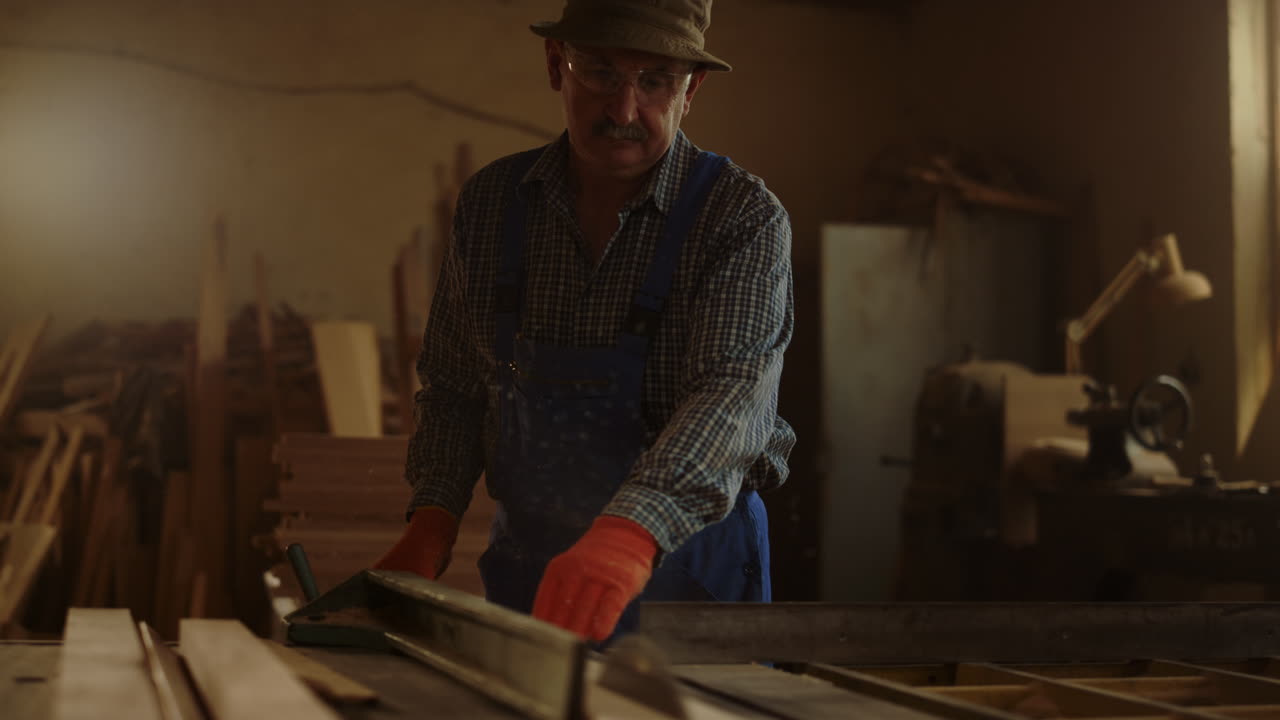 Premium stock video - Elderly man using saw machine indoors. serious ...