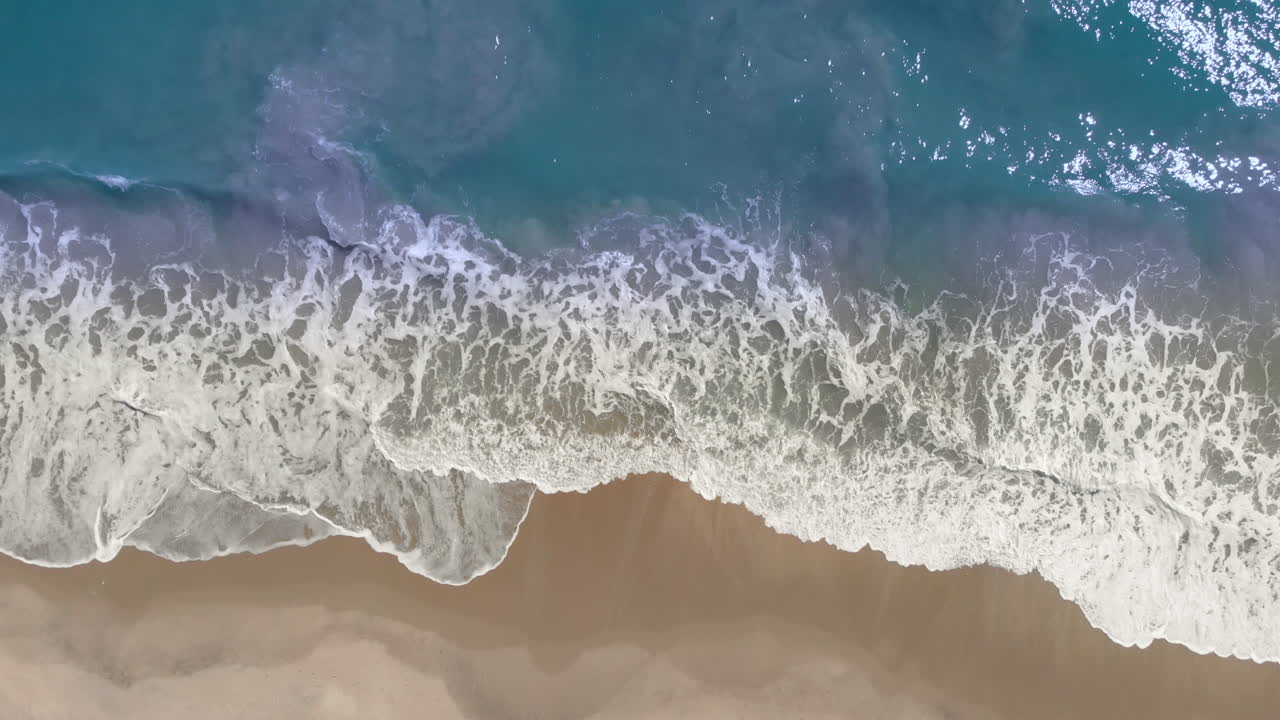 Premium stock video - Aerial view of looping ocean wave reaching the ...