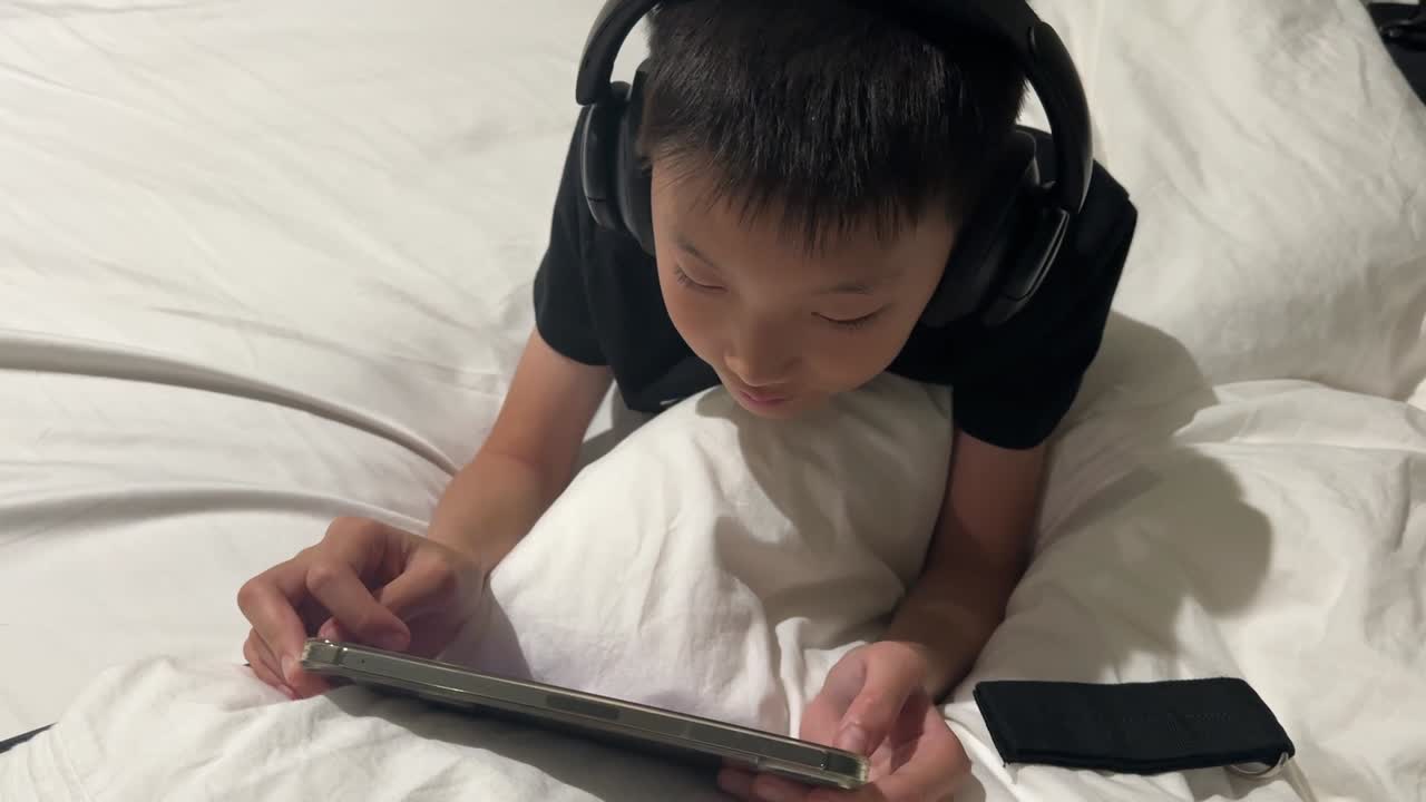 Premium stock video - Young boy on electronic device