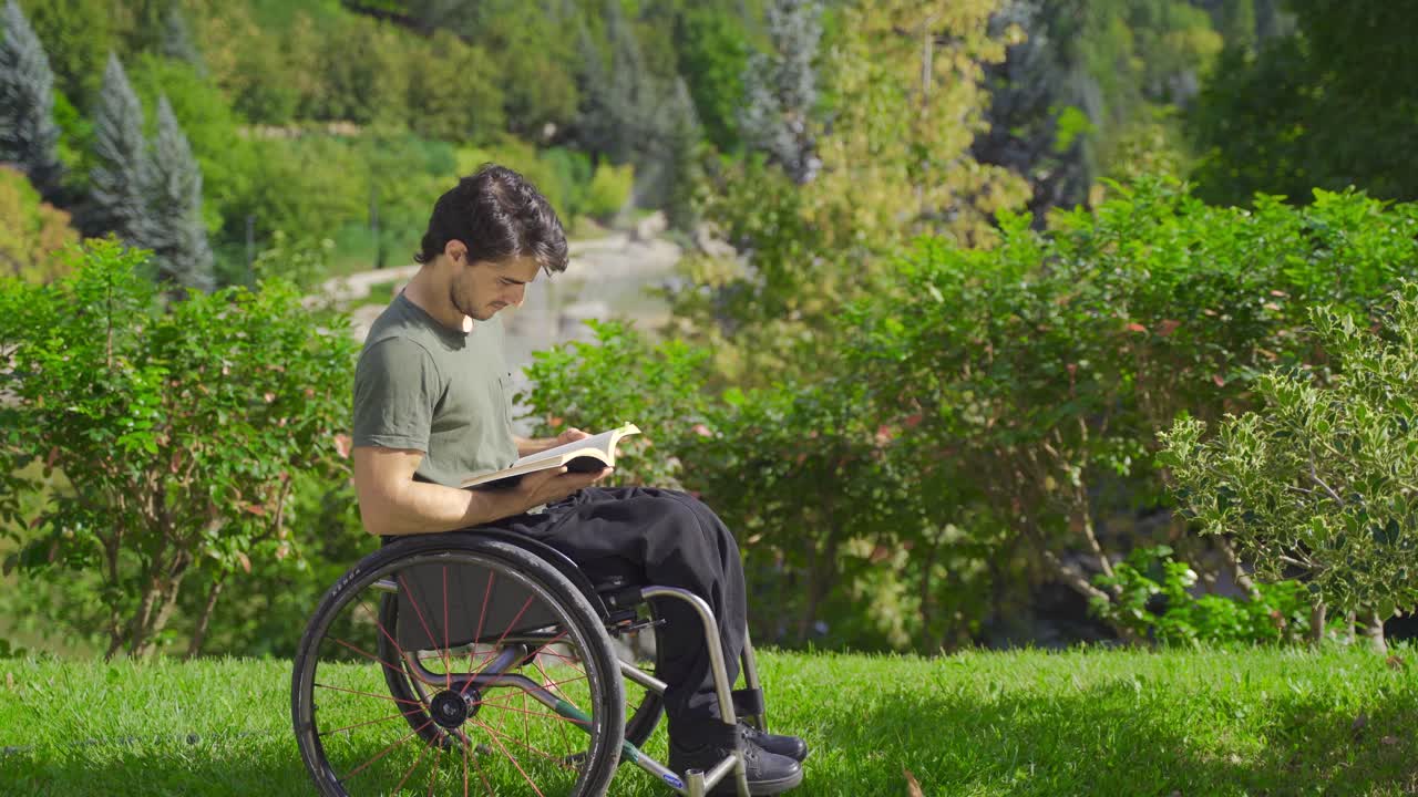 Premium stock video - Disabled teenager in a wheelchair reading a book ...