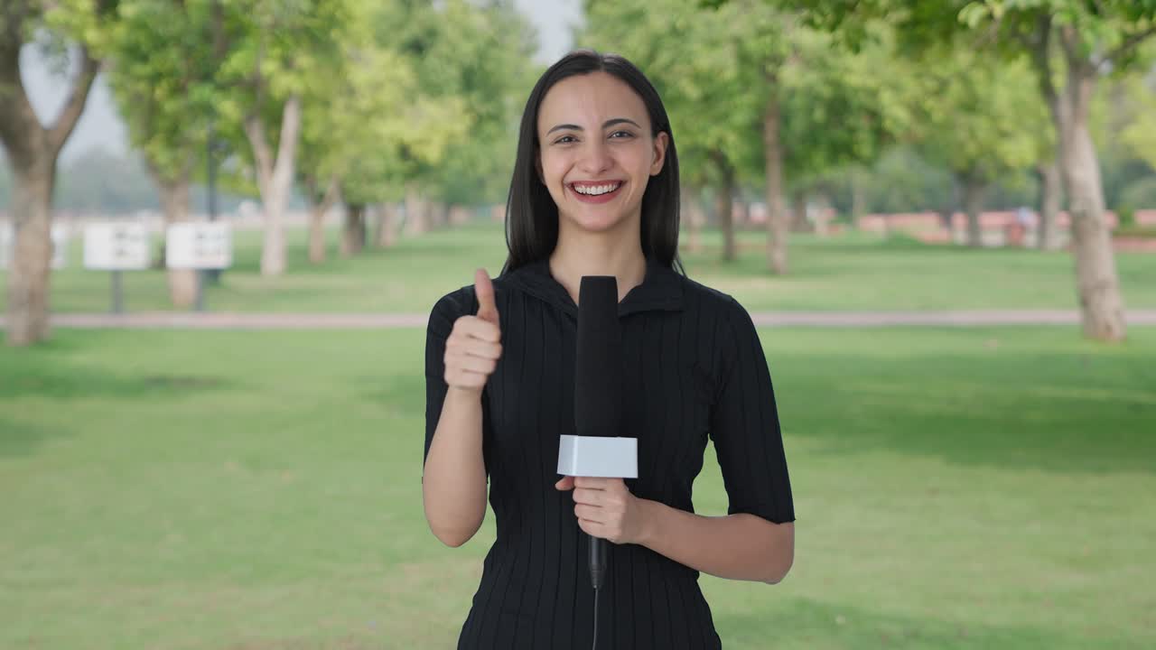 Premium stock video - Happy indian female news reporter showing thumbs up