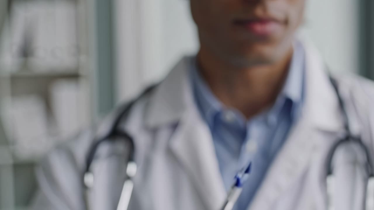 Close-up video of a doctor in a white coat, slightly blurred focus ...