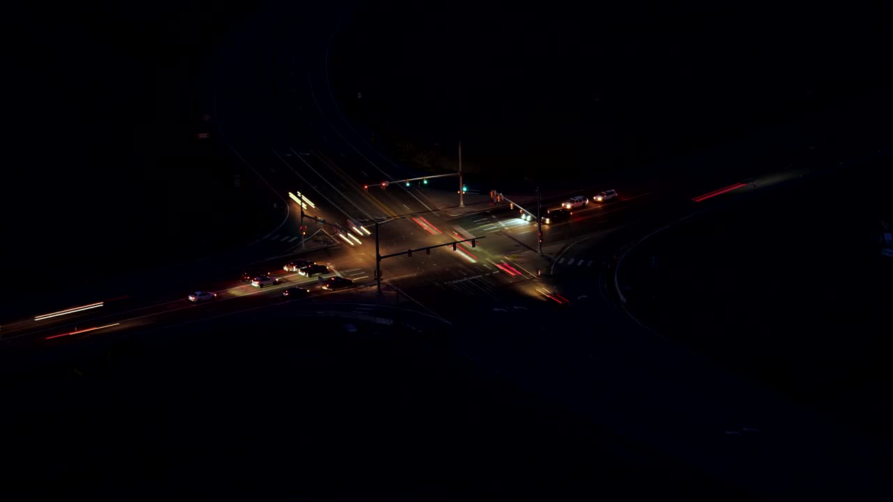 Aerial time lapse of night time traffic flow at a highway intersection ...
